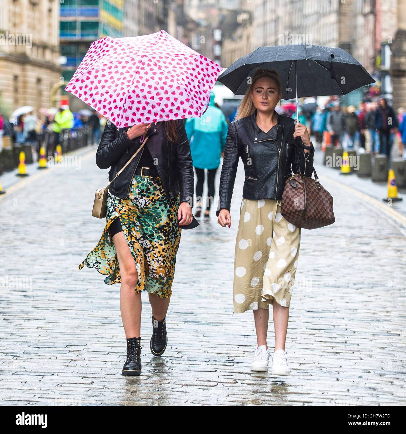 Public on Edinburgh's Royal Mile don poncho's and umbrella's as heavy ...