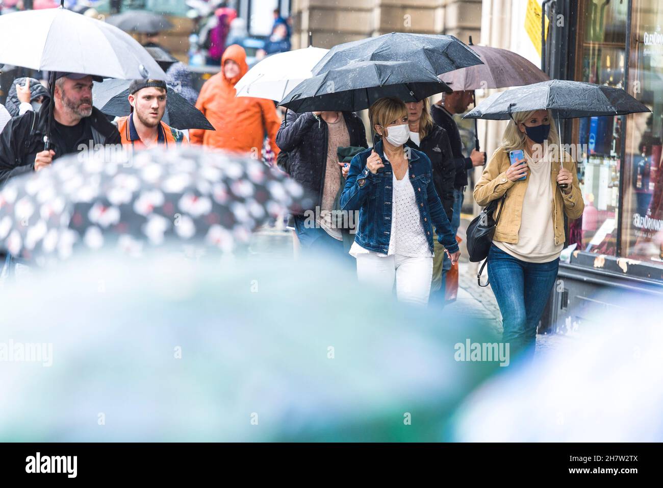 Public on Edinburgh's Royal Mile don poncho's and umbrella's as heavy ...