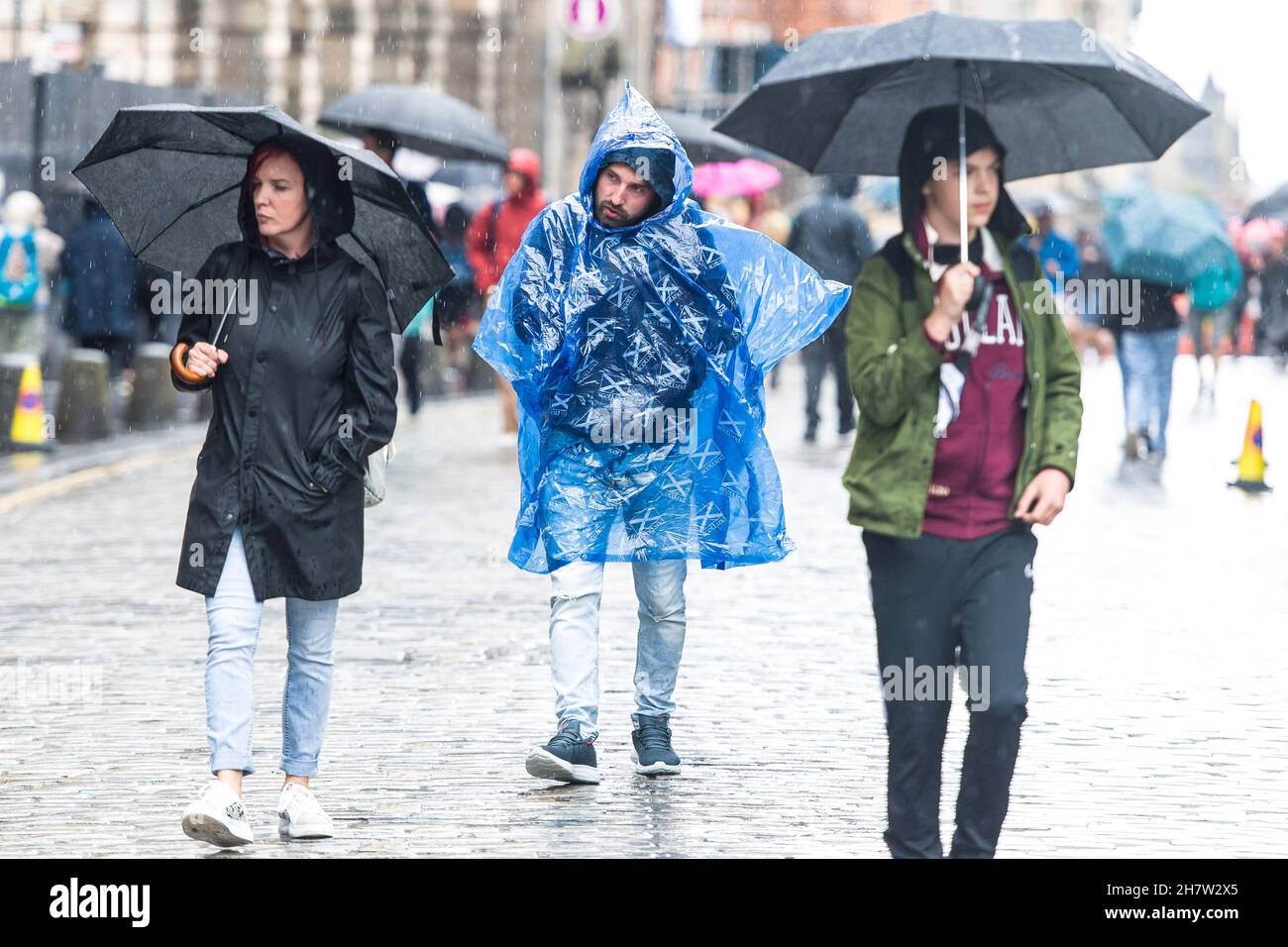 Public on Edinburgh's Royal Mile don poncho's and umbrella's as heavy ...
