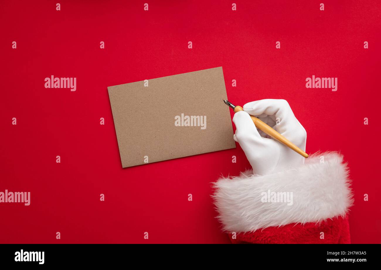 Santa Claus wiring a festive message on blank paper Stock Photo - Alamy