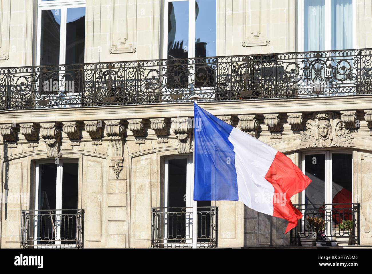 The French flag hung on the tenement house, waving in the wind Stock ...