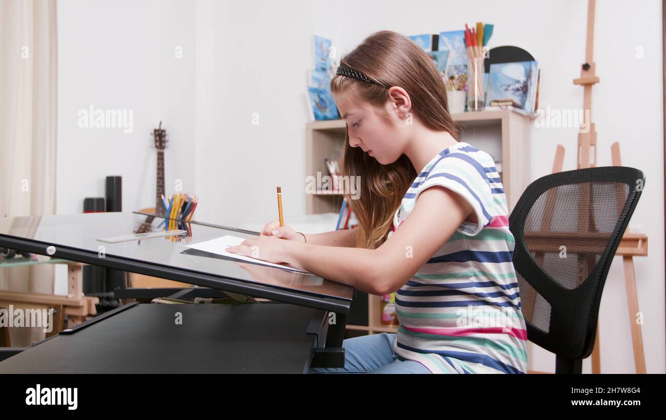 Little child painter drawing creative sketch using graphic pencil ...