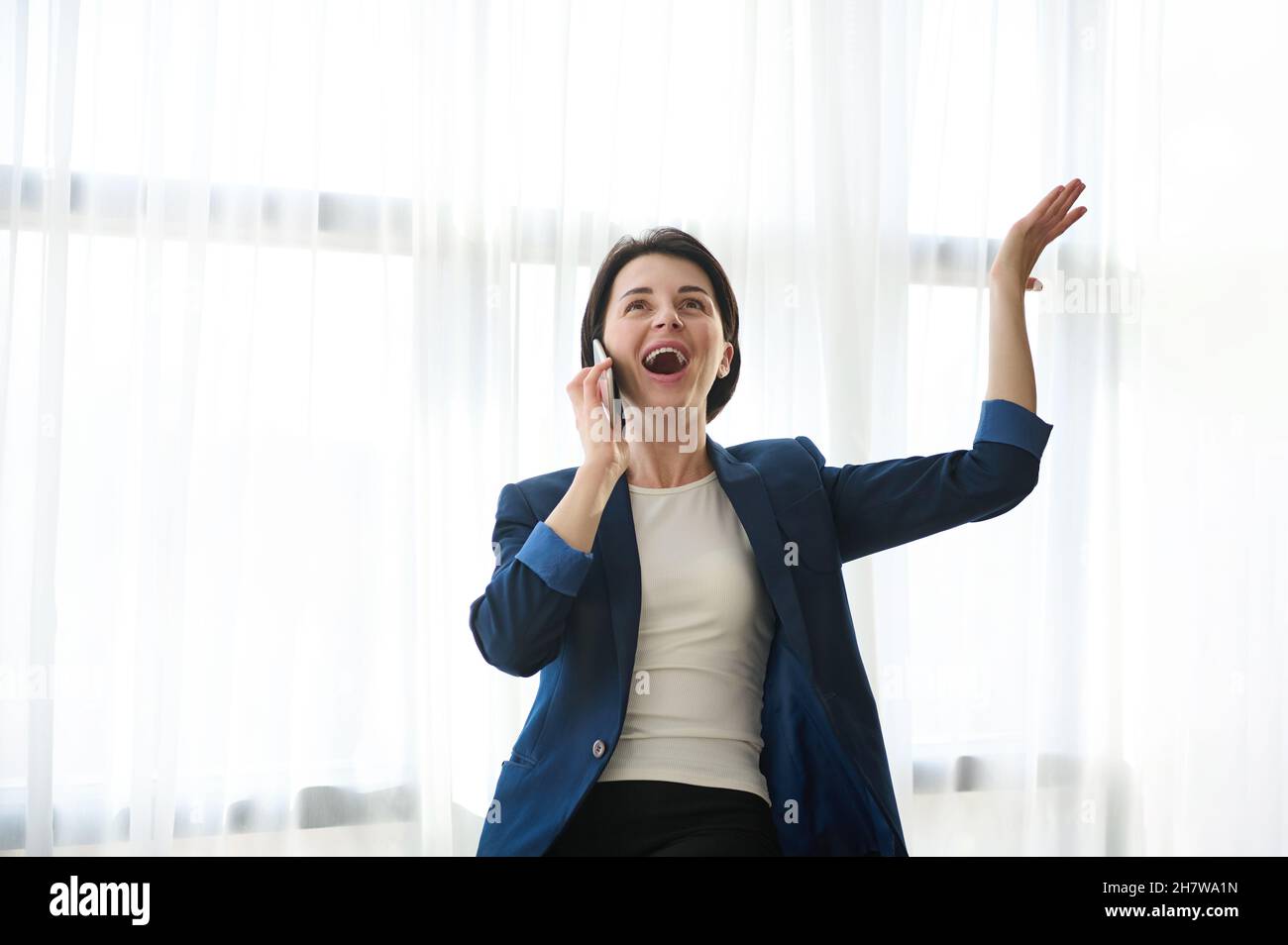 Attractive young business woman enjoys talking on a cell phone while ...