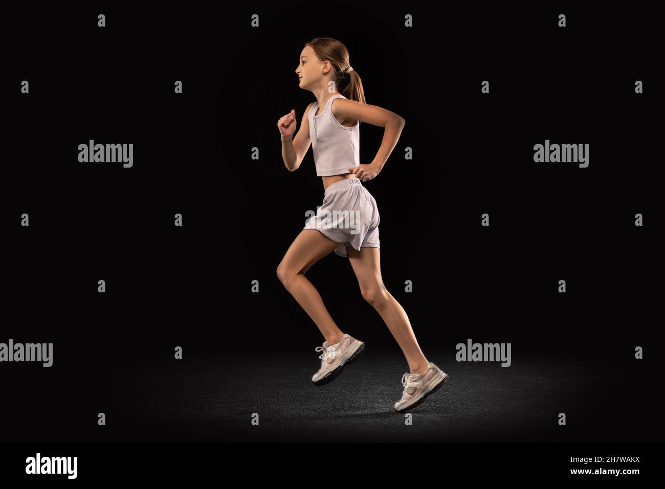Full-length portrait of girl, teenager, athlete training running ...