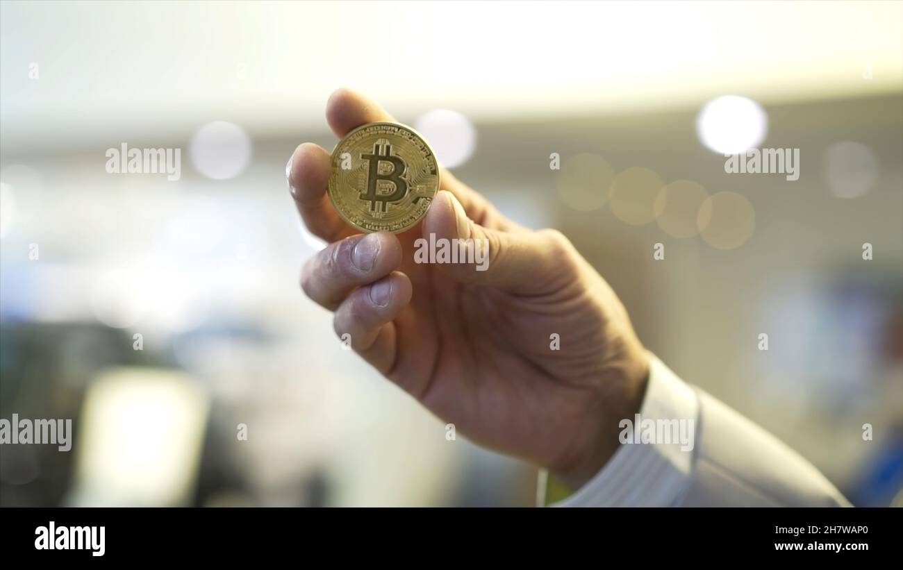 Businessman hand holding glowing bitcoin sign. Stock. Virtual money ...