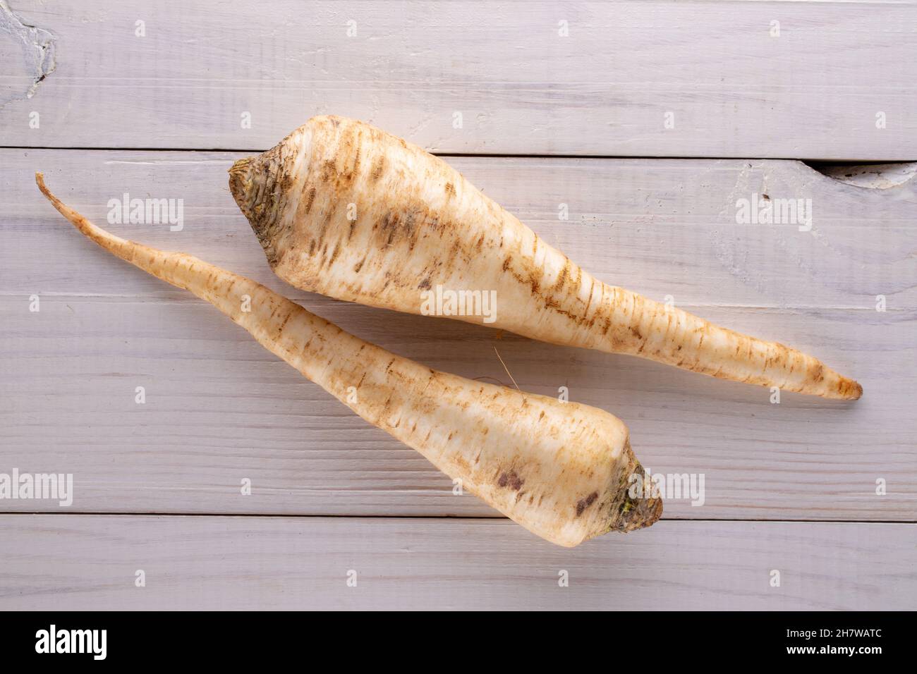 Two fragrant parsnip roots on a wooden table, close-up, top view Stock ...