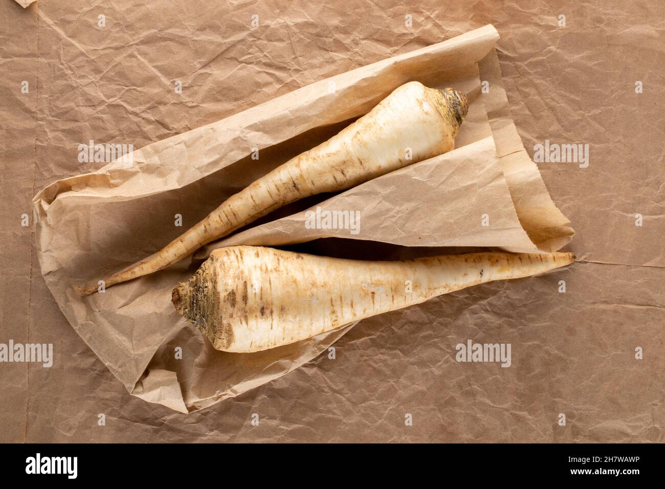 Two fragrant parsnip roots on craft paper, close-up, top view Stock ...