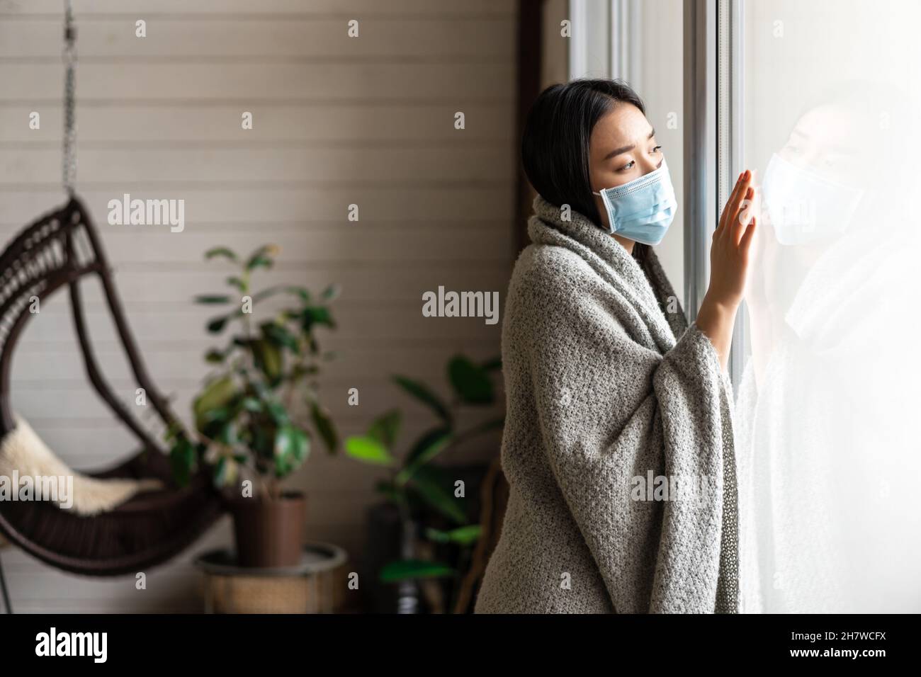 Sick asian woman staying at home on quarantine from covid-19, wearing ...