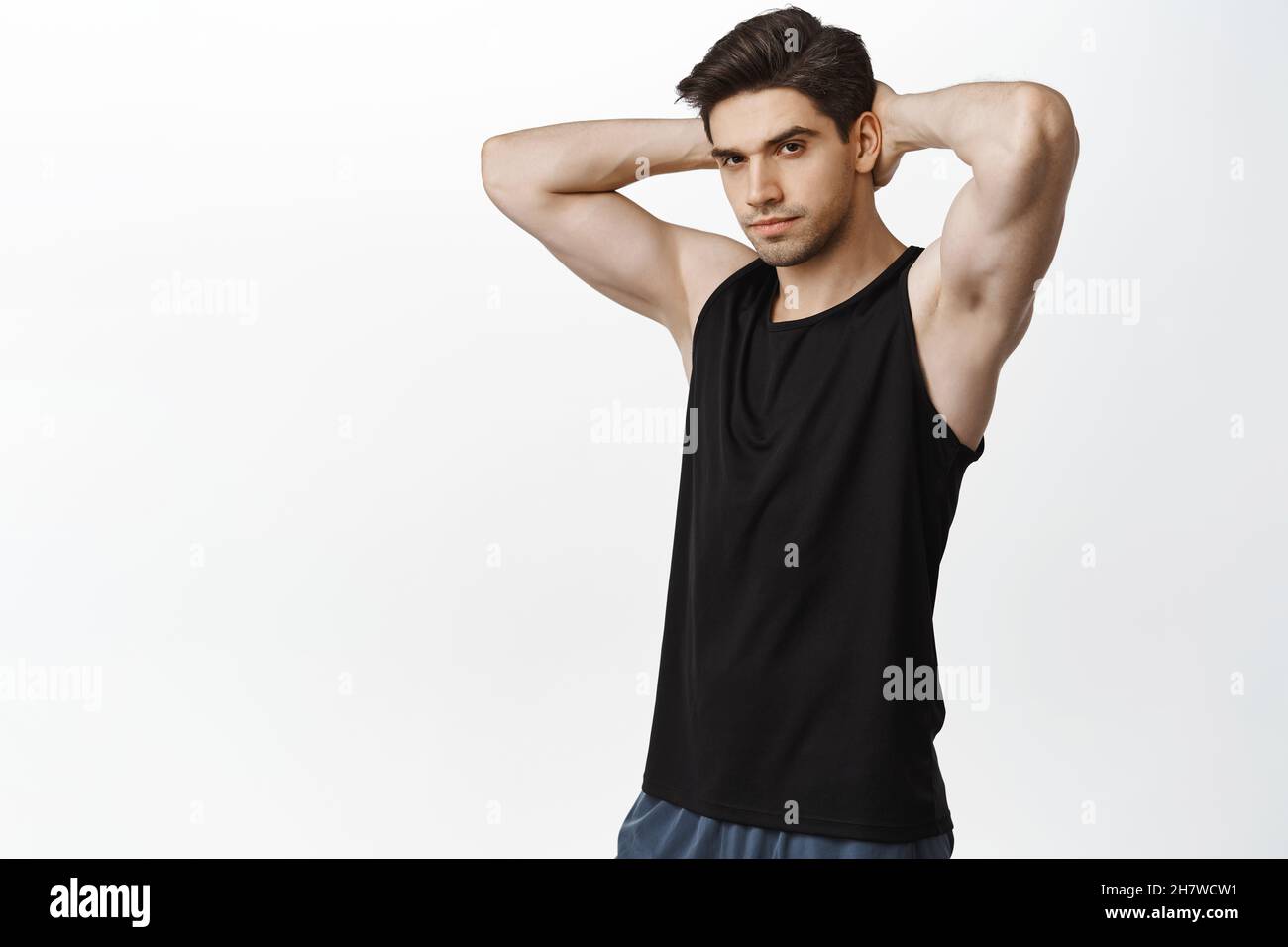 Sport and fitness concept. Athletic guy in tank top, holding hands ...