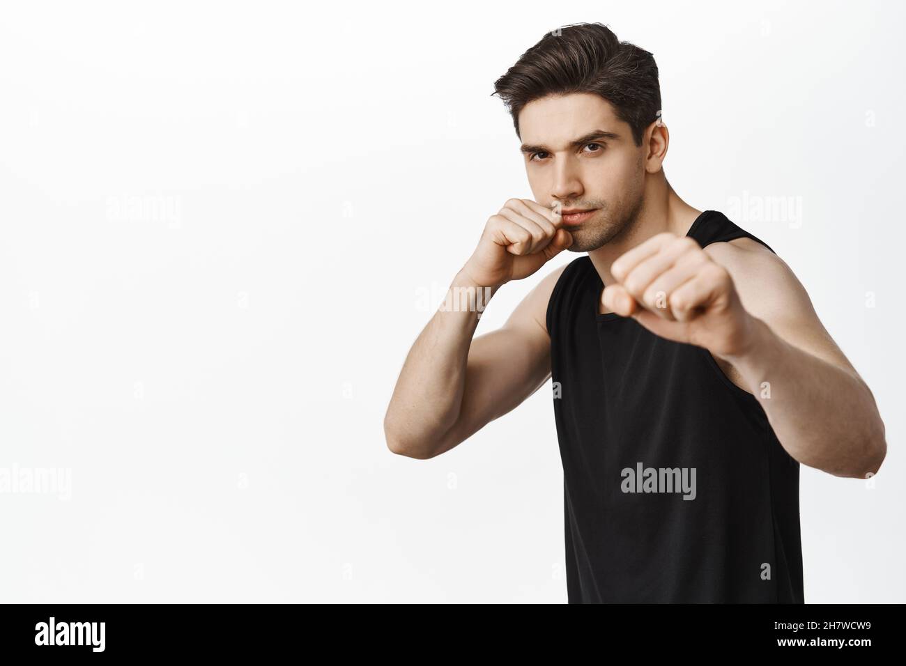 Portrait of handsome man boxing, wrestle, practice punches and workout ...