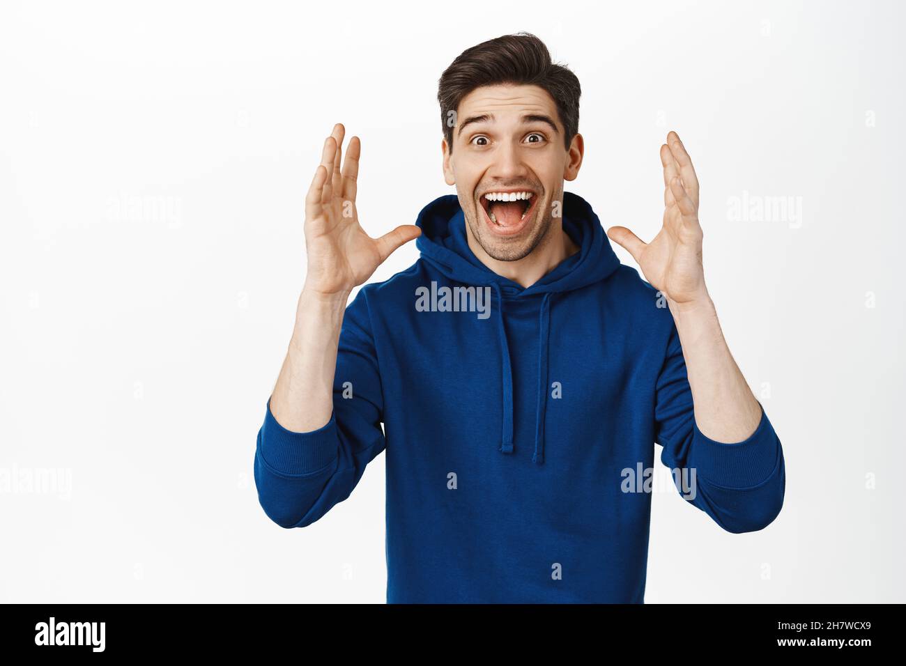 Super happy guy screams of joy, smiling and looking amazed at camera ...