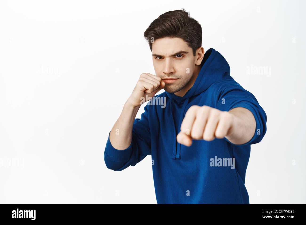 Image of serious man making punch, fighting, wrestle with someone ...
