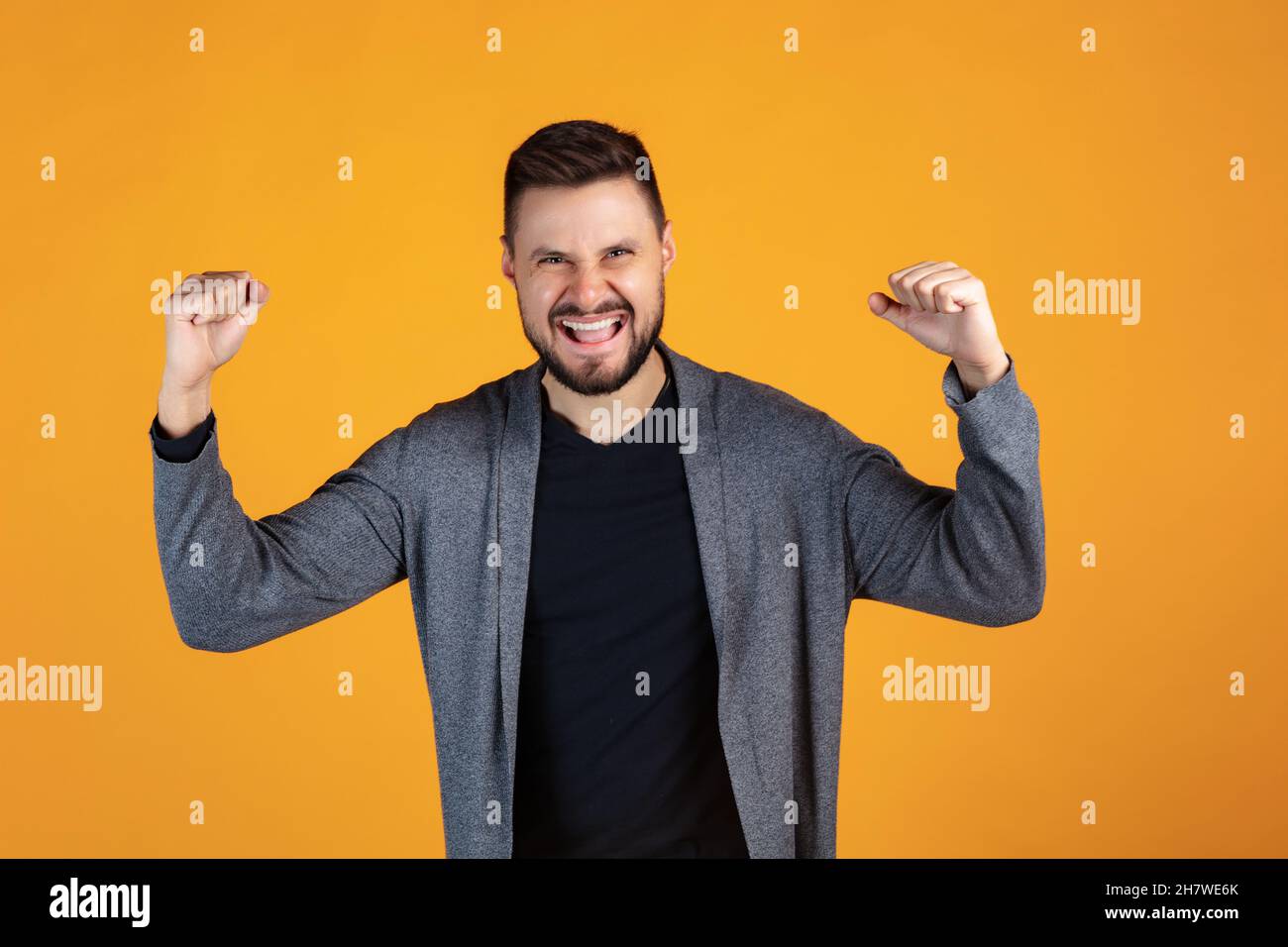 Cropped portrait of happy and excited man in gray cardigan cheerfully ...