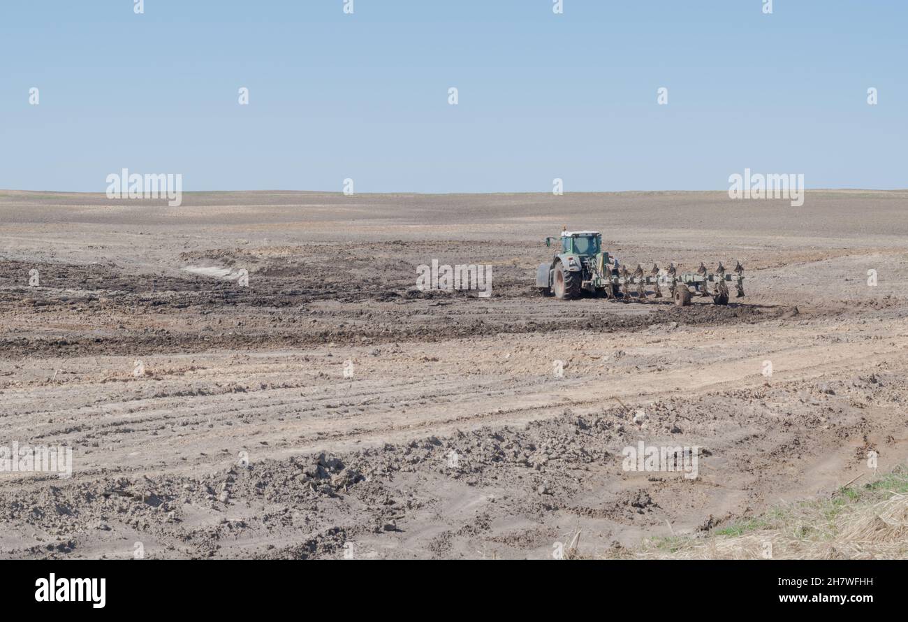 The tractor plows the ground. Spring field work. Preparation for sowing ...
