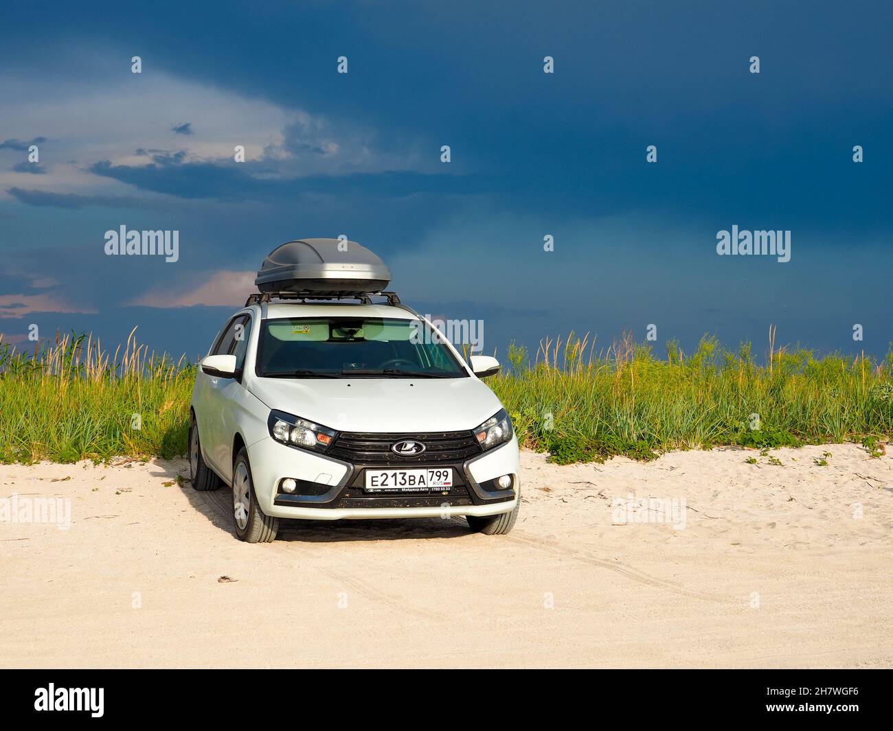 Krasnodar Region. Russia. July 12, 2021. White modern Russian car Lada Vesta with a luggage box ...