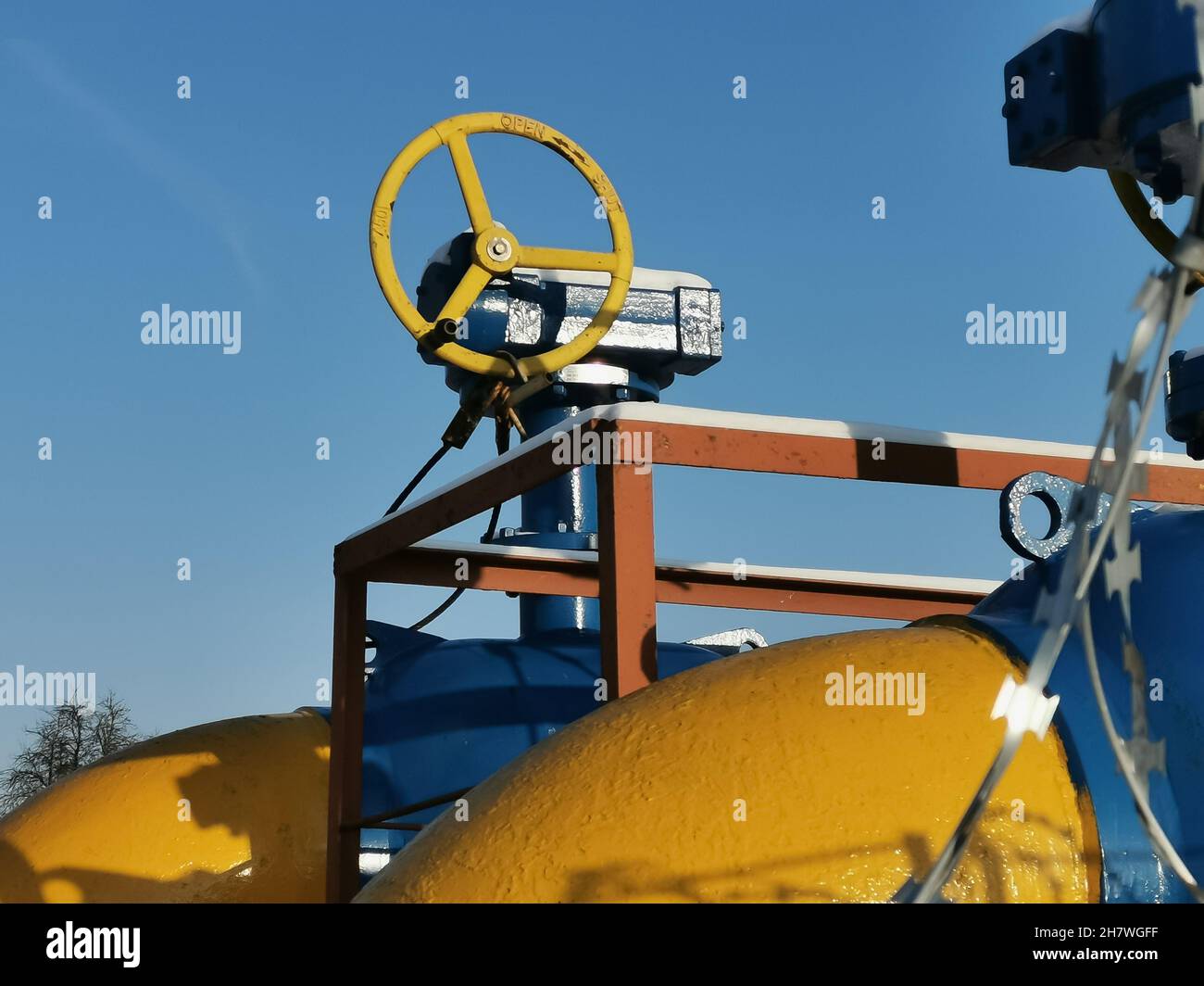 Against the background of a bright blue sky, a gas compressor station ...