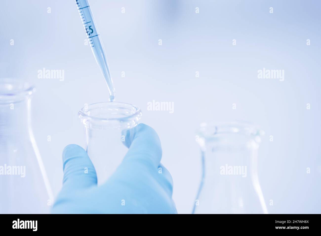 Doctor or scientist using pipette to drop a sample to test tube in ...