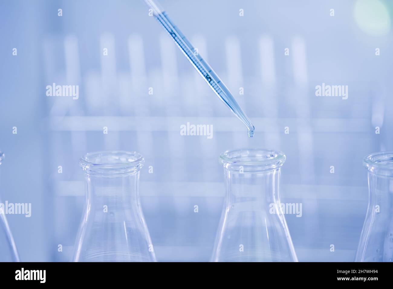 Doctor or scientist using pipette to drop a sample to test tube in ...
