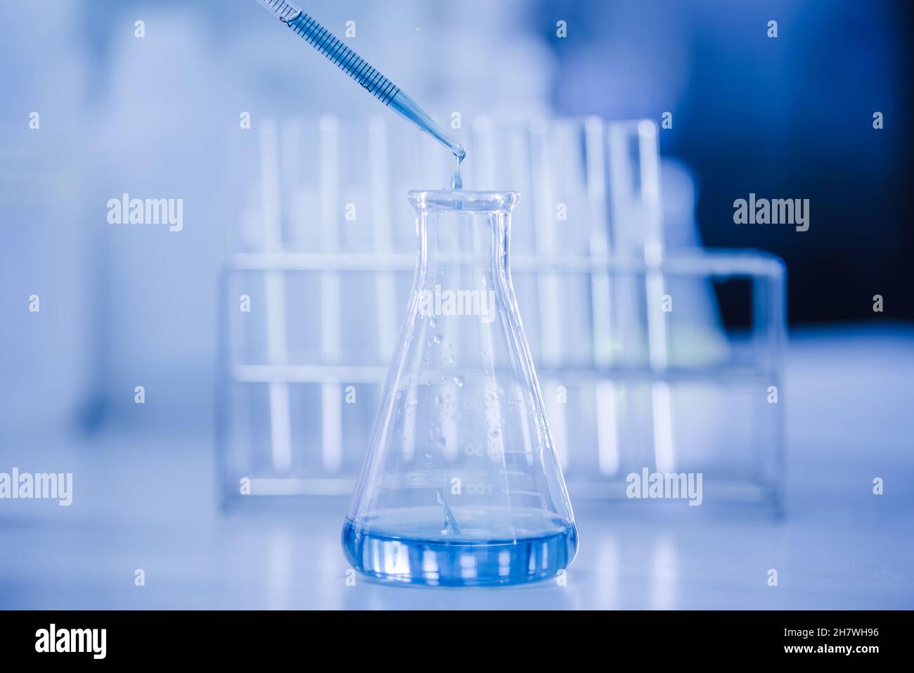 Doctor or scientist using pipette to drop a sample to test tube in ...