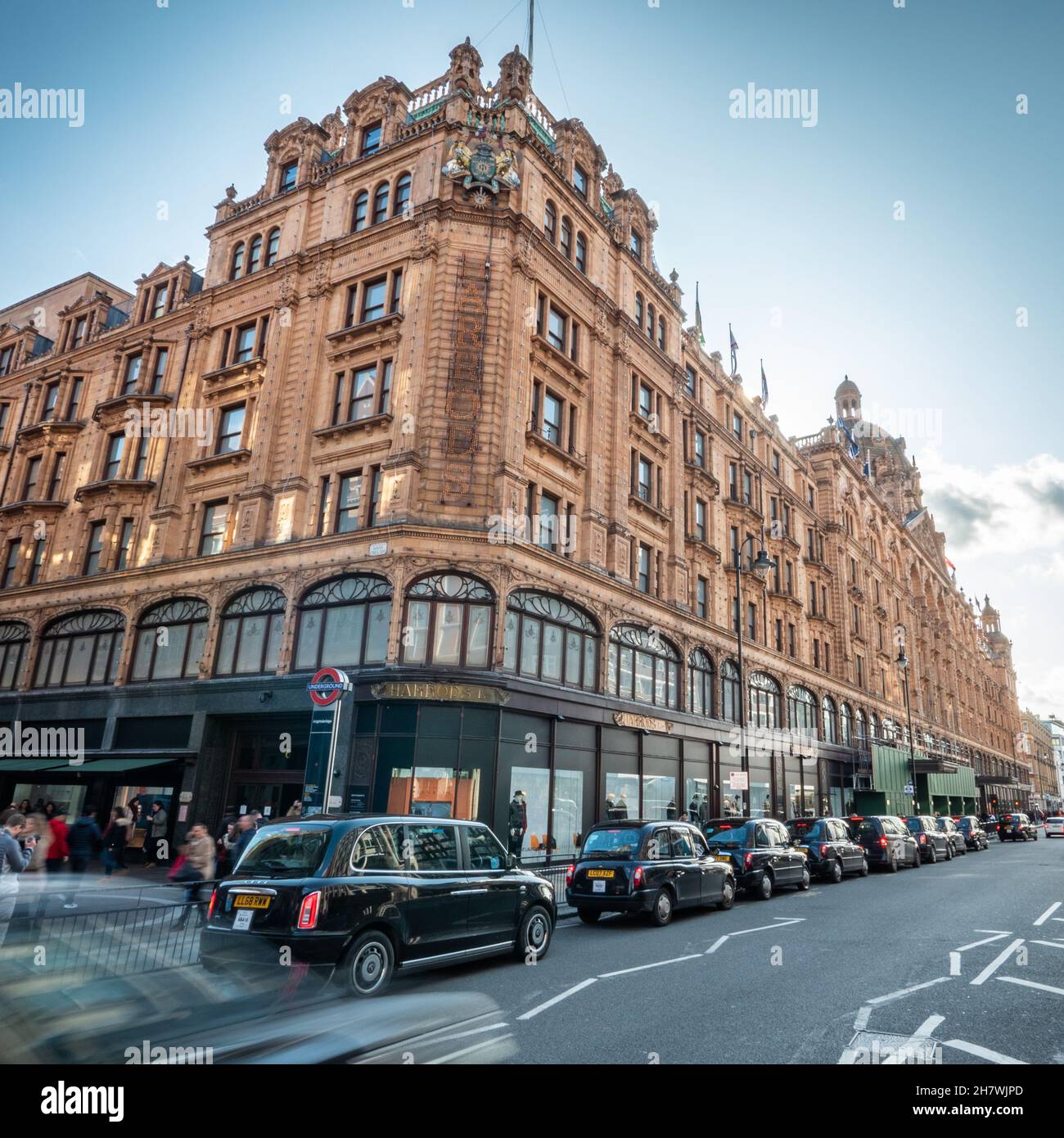 Harrods, London. Shoppers and black cab taxis waiting outside the ...