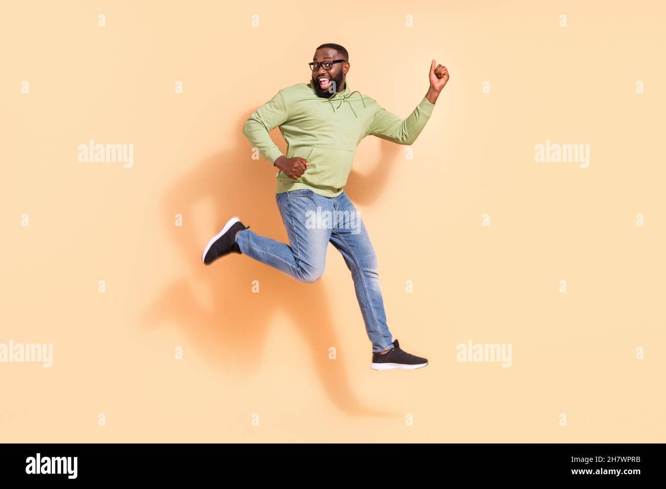 Full length photo of energetic active man jumping have fun celebrate ...
