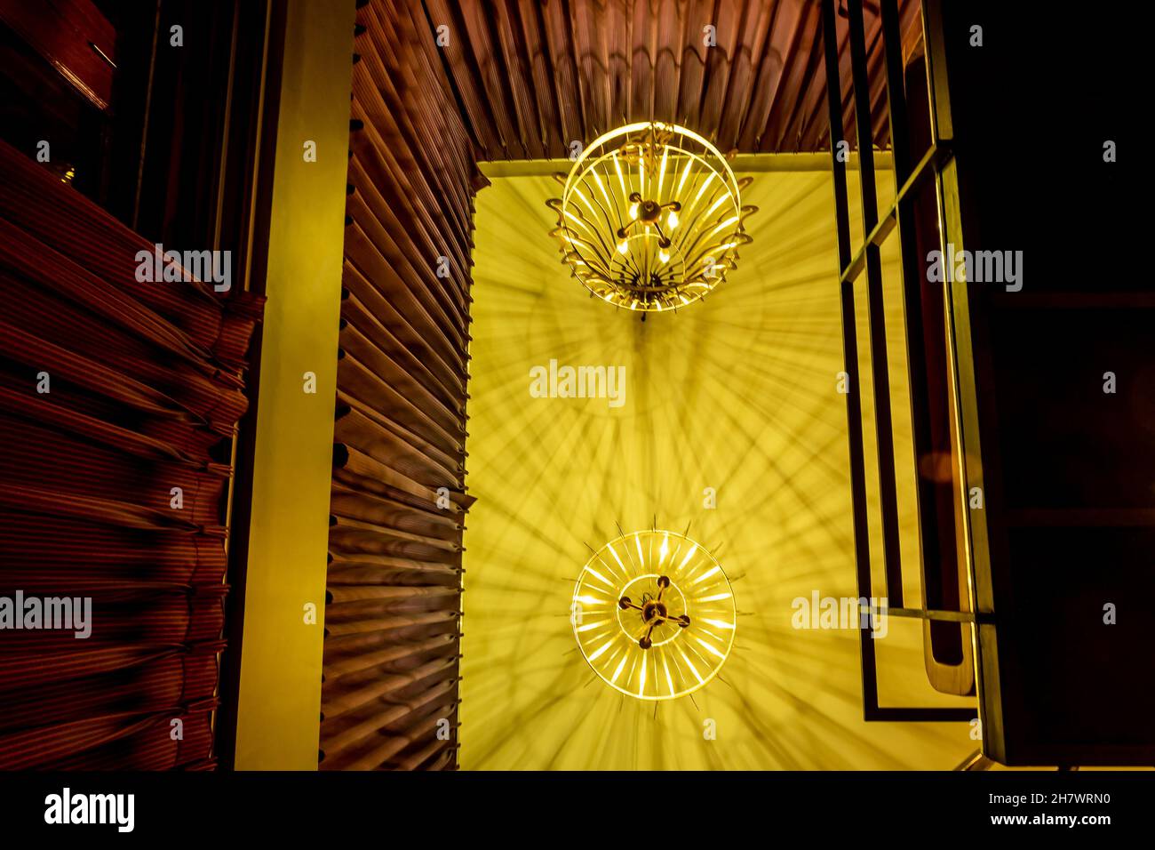 Warm colored light from a modern ceiling pendant lamp Stock Photo - Alamy