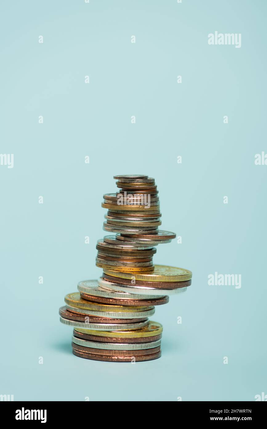 stack of golden and silver coins on blue background with copy space ...