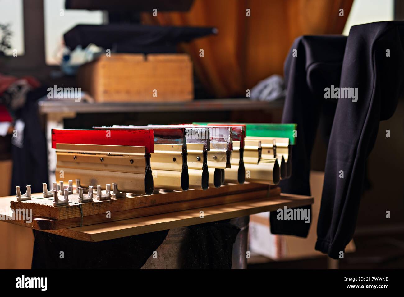 serigraphy production. squeegees on wooden desk. printing images on t ...