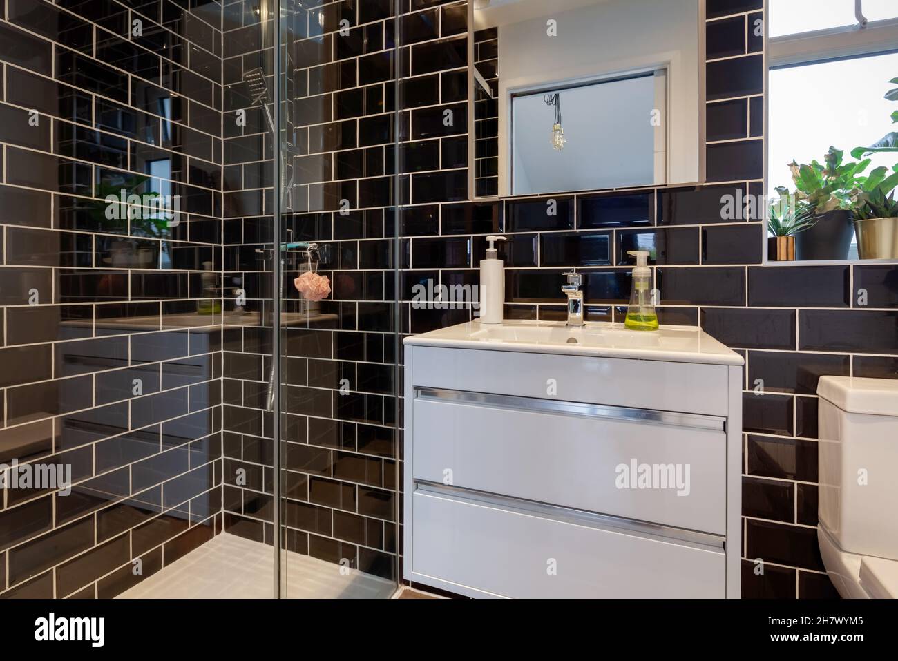 Generic Shower washroom wc staging with gloss black tiled walls, glass ...