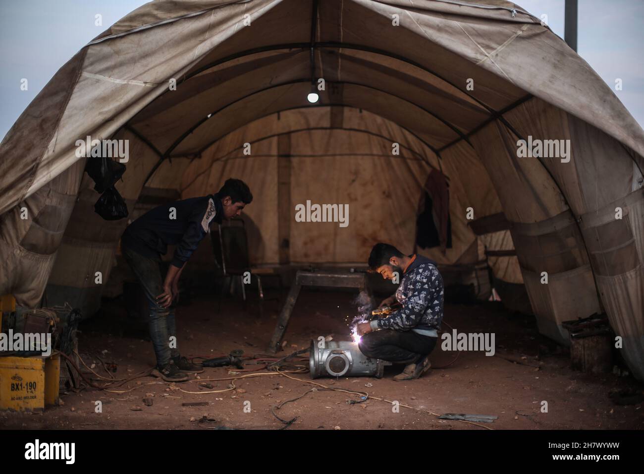 Atma, Syria. 25th Nov, 2021. A Syrian refugee man works on making wood ...