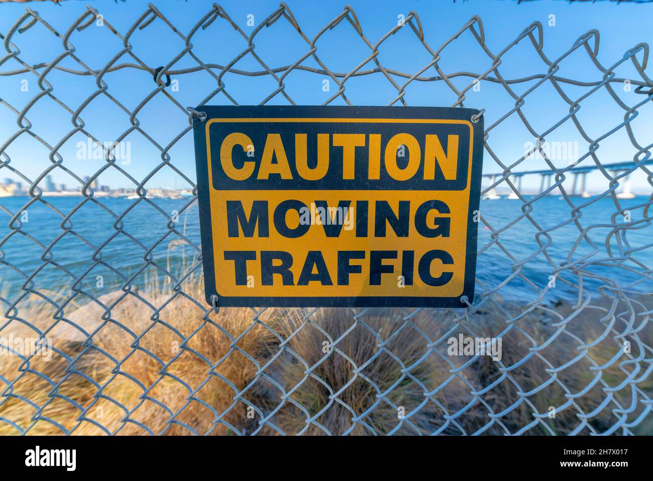 Caution moving traffic sign on a mesh wire fence at Coronado, San Diego ...