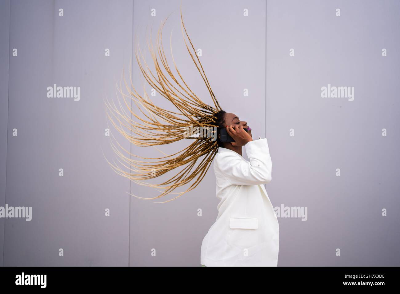 Photo with motion of a afro woman moving her hair to the back while ...