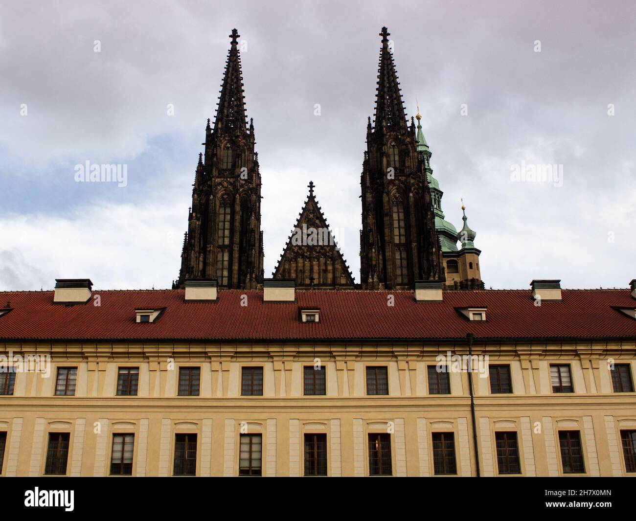 Yellow building in front of a cathedral Stock Photo - Alamy