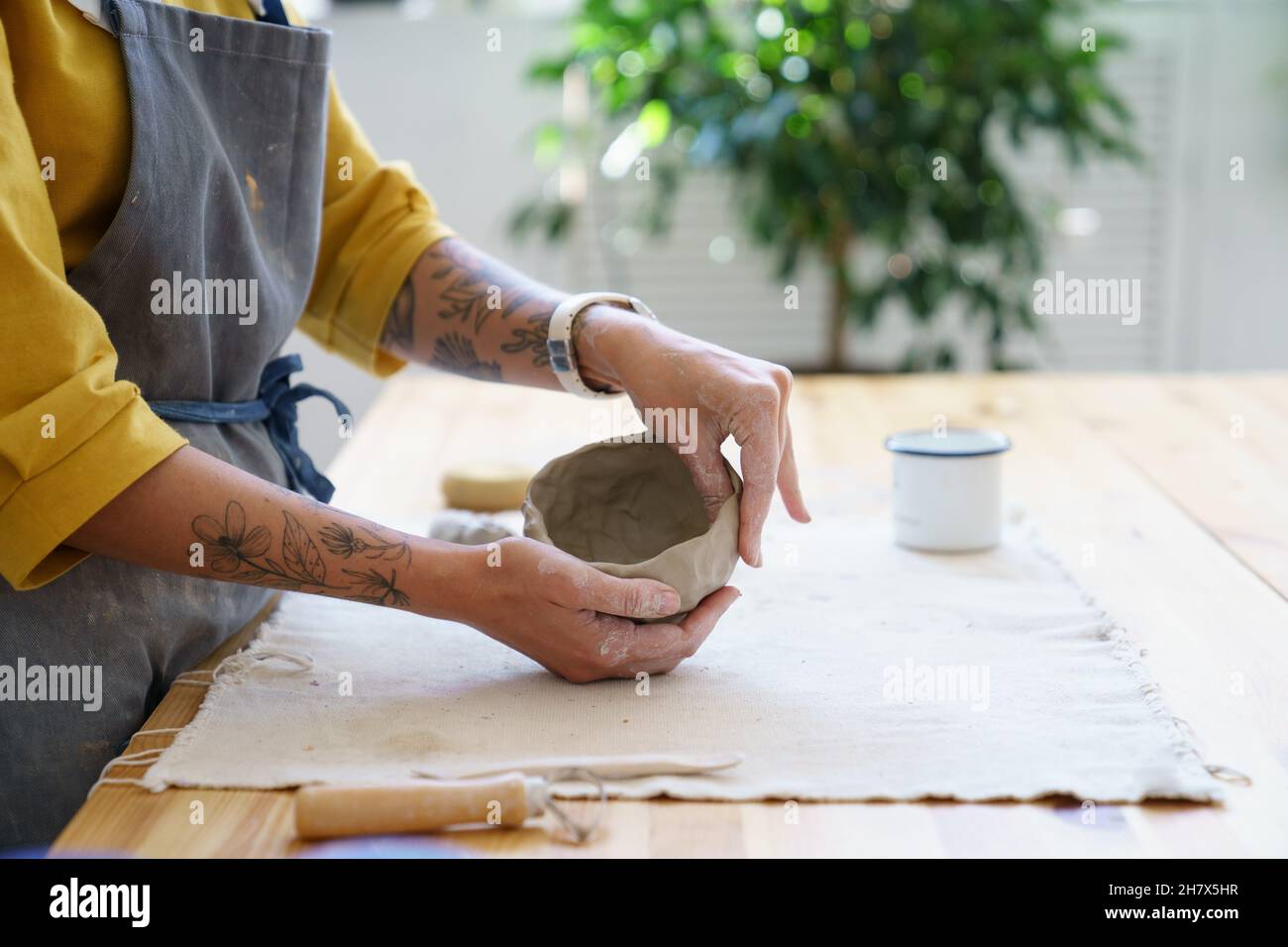 Creating pottery: table in ceramic studio with master hands shaping ...