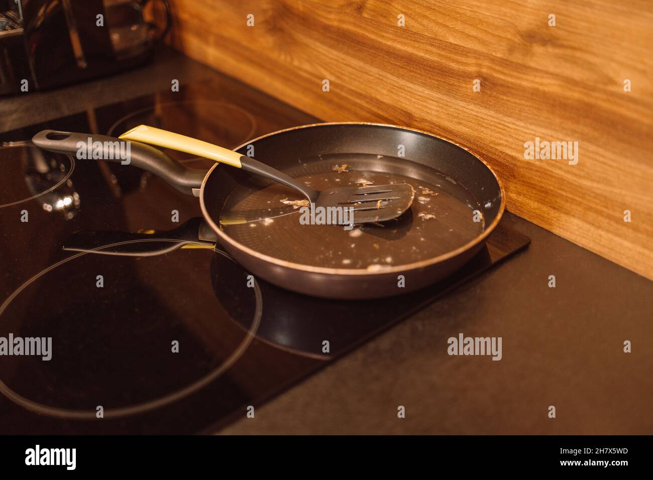 dirty frying pan with plastic spatula after cooking on an induction ...