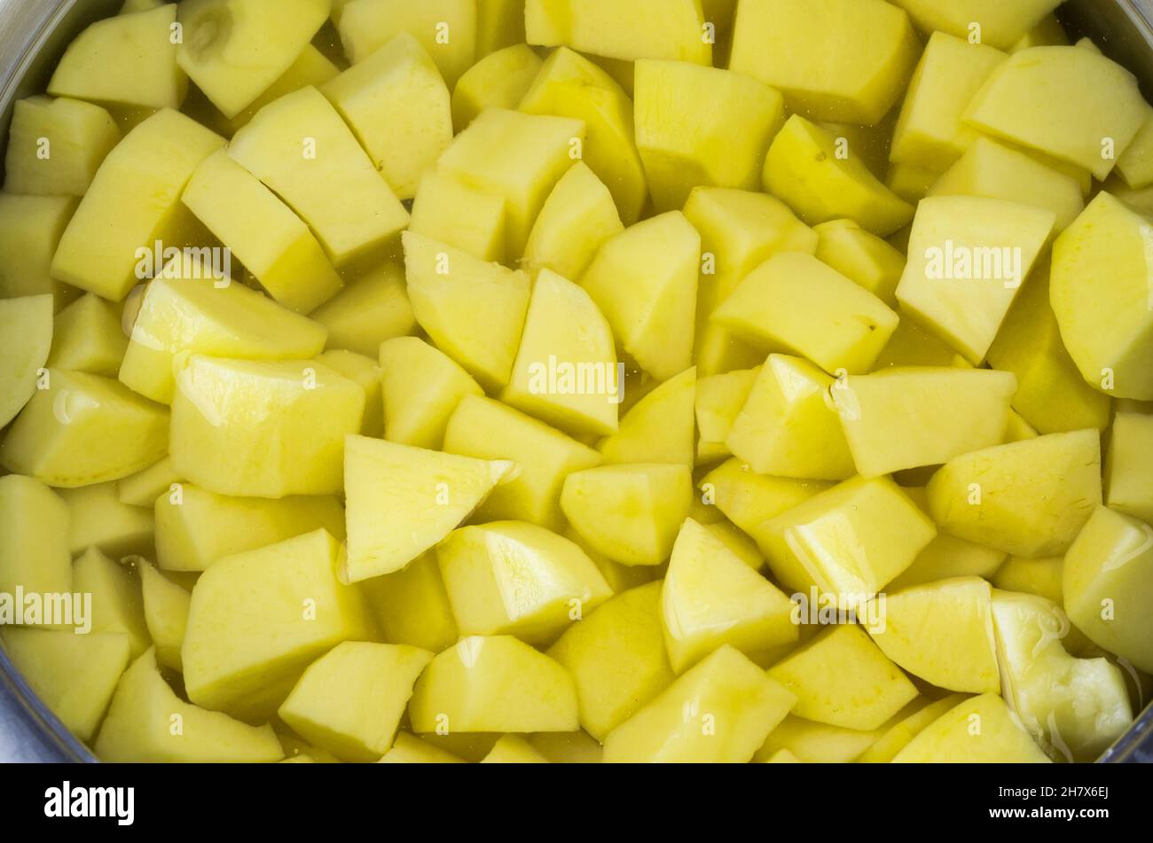Cut peeled raw potato in the water. Top view Stock Photo - Alamy