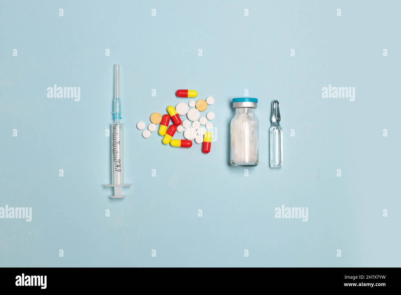 Drugs heroin powder pills and syringes on blue background. Safety at ...