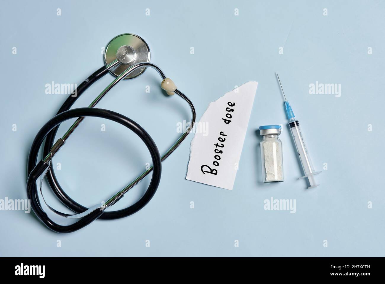 New COVID-19 vaccine booster dose with a vial of vaccine and syringe on ...