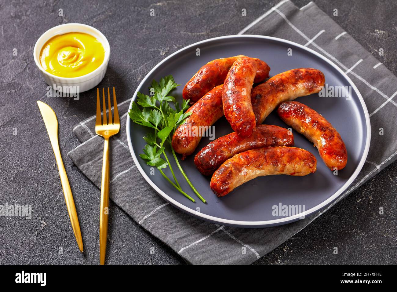 grilled lamb sausages, bangers on a plate on a concrete table ...