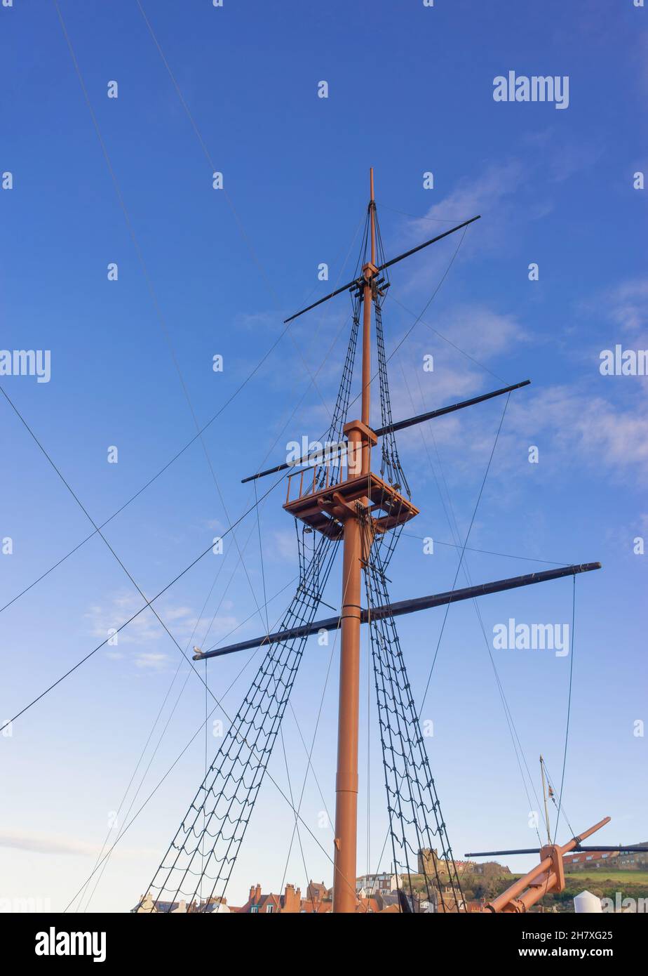 The mast of a tall ship, shot from low angle, against a sky with light ...
