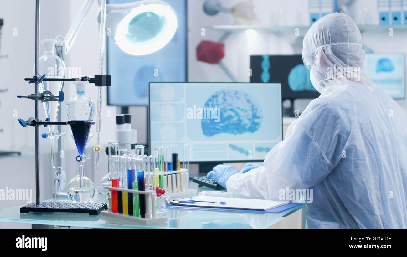 Specialist researcher with ppe equipment analyzing brain activity ...