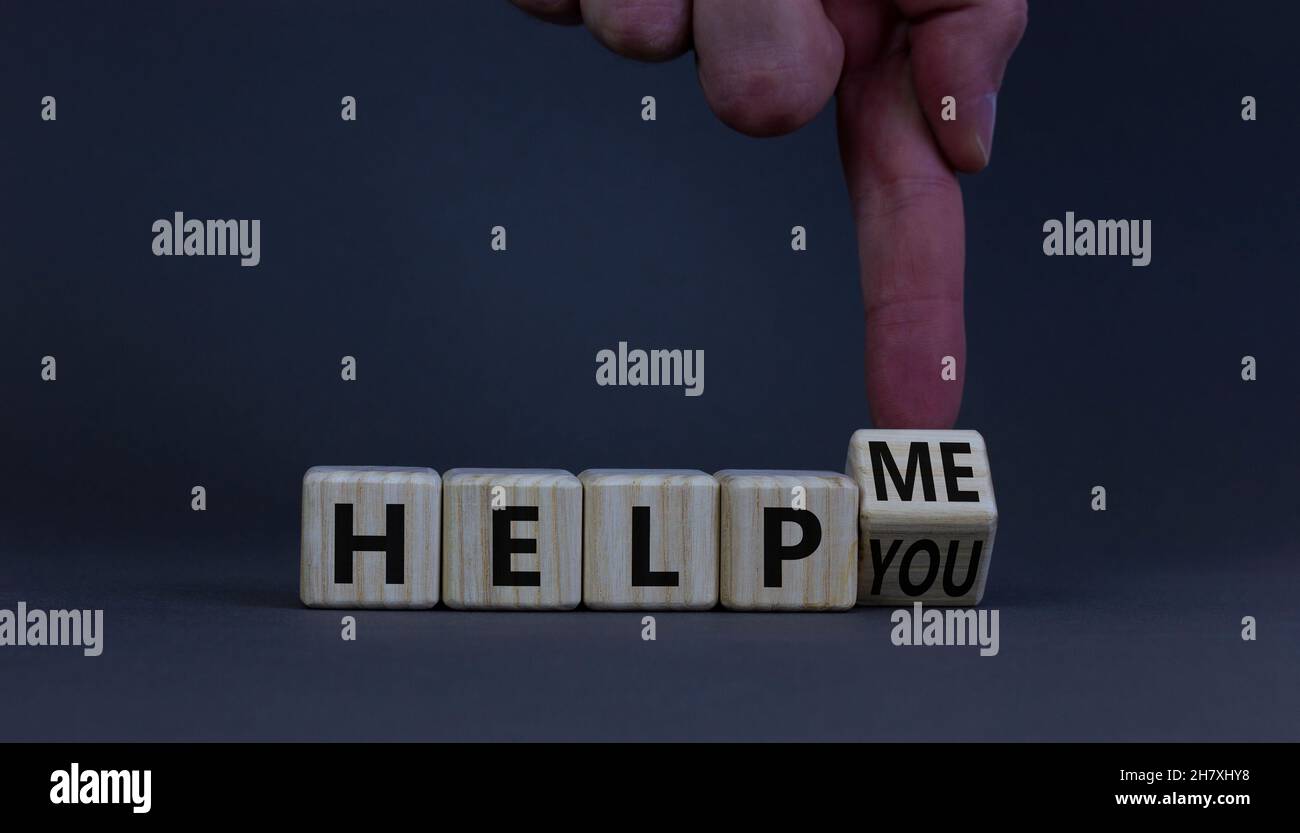 Help you or me symbol. Businessman turns a cube and changes words help ...