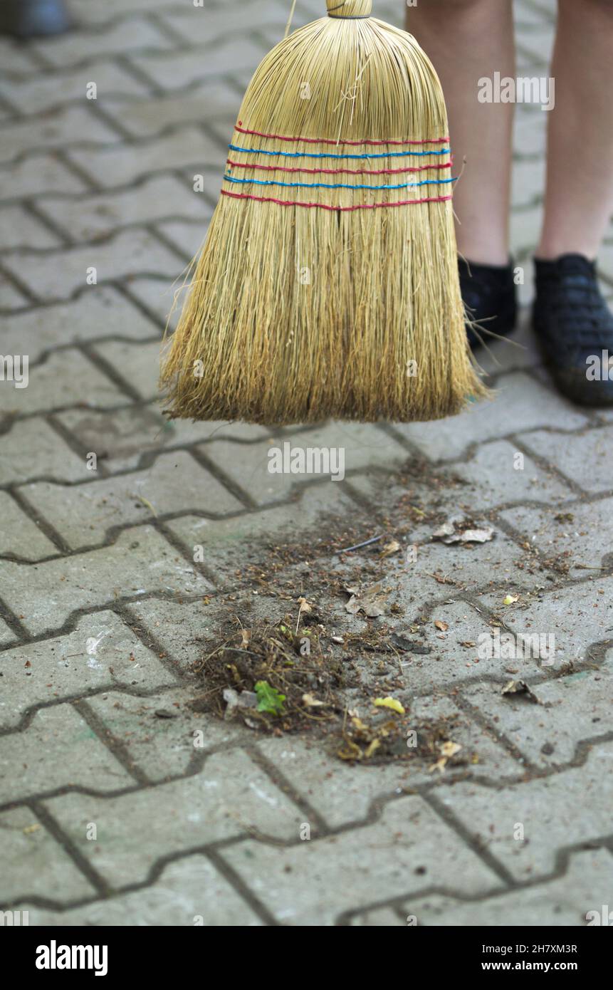 Woman sweeping waste on the stone ground Stock Photo - Alamy