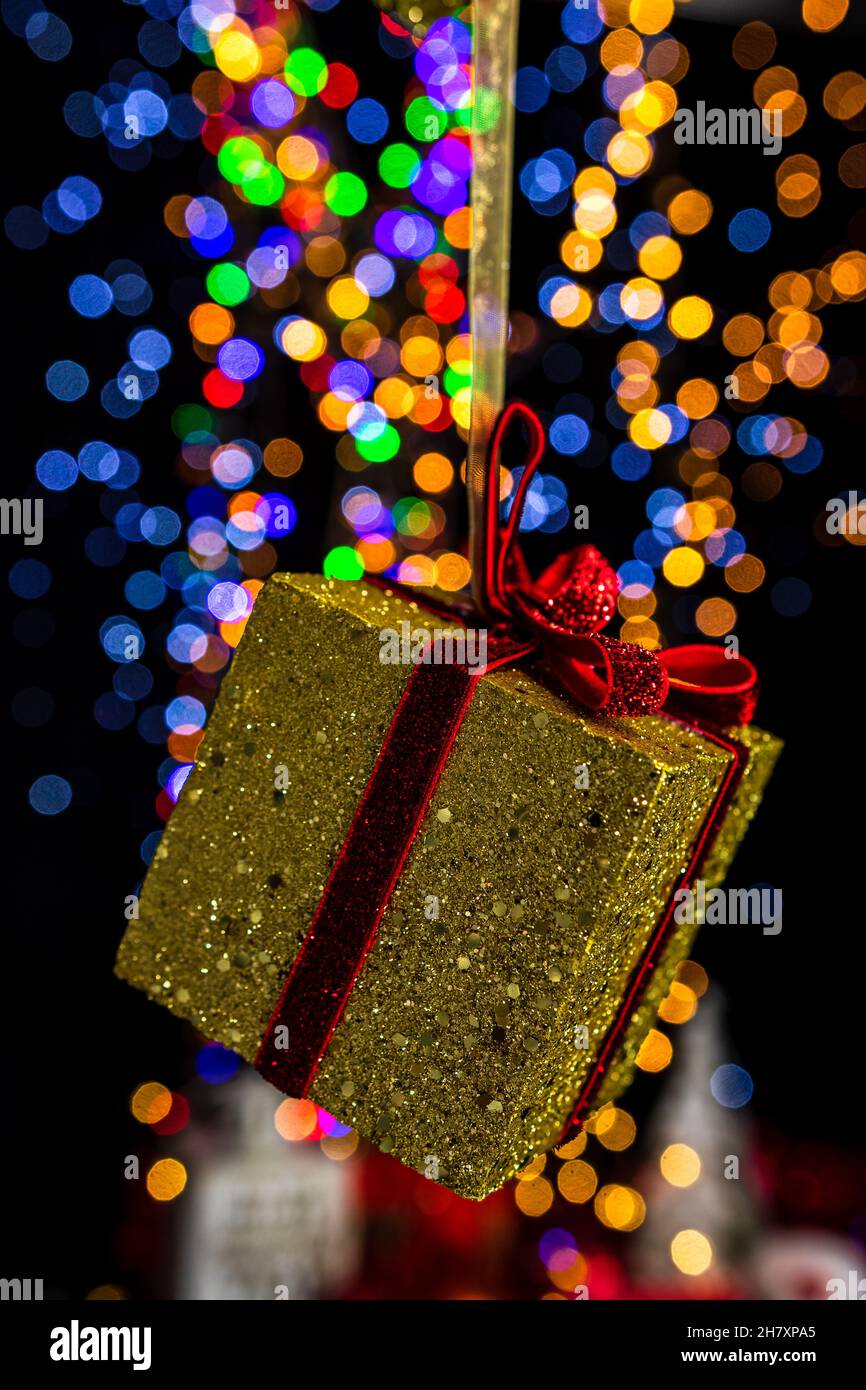 Holding Christmas decoration against bokeh lights background Stock ...