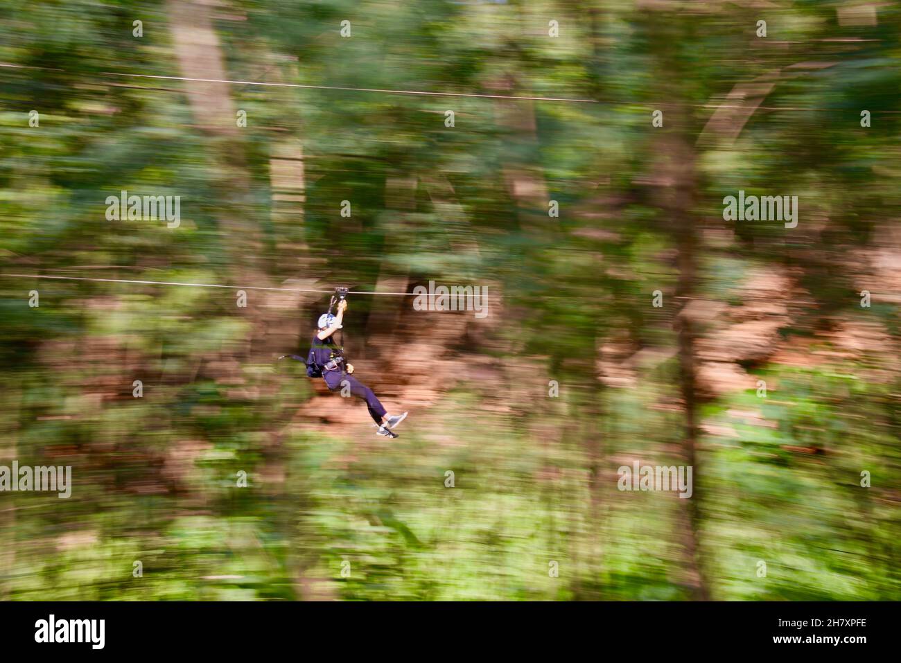 Fast moving motion, thrill and excitement of zipline run down tropical ...
