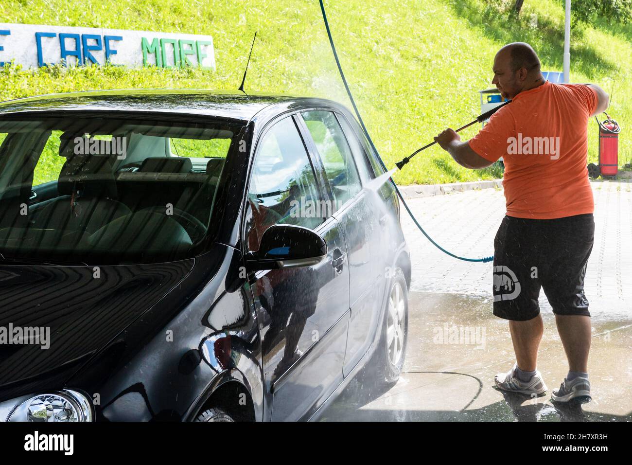 Washing and cleaning car in self service car wash station. Car washing using high pressure water ...