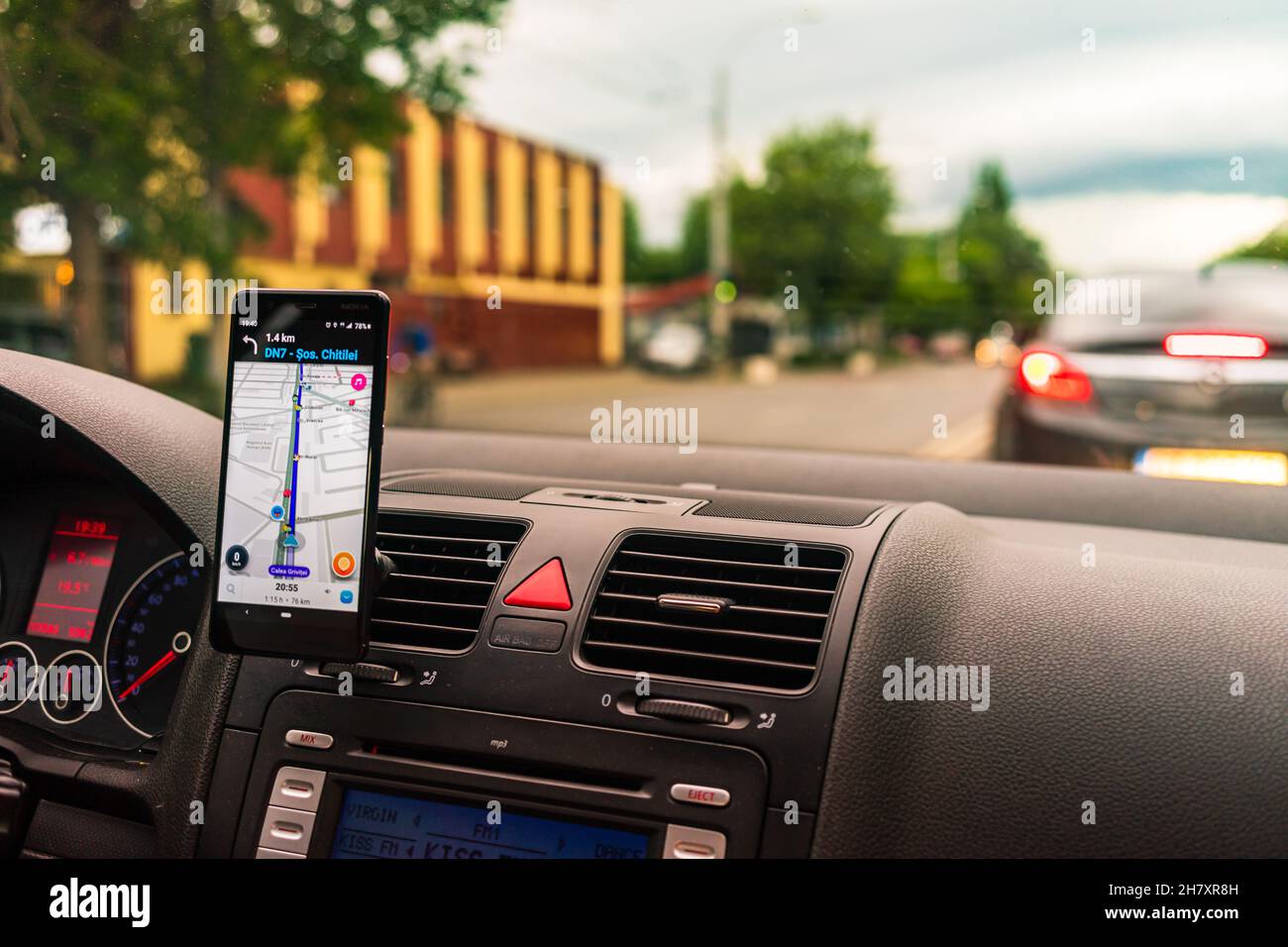 Driving and using waze maps application on smartphone on car dashboard ...