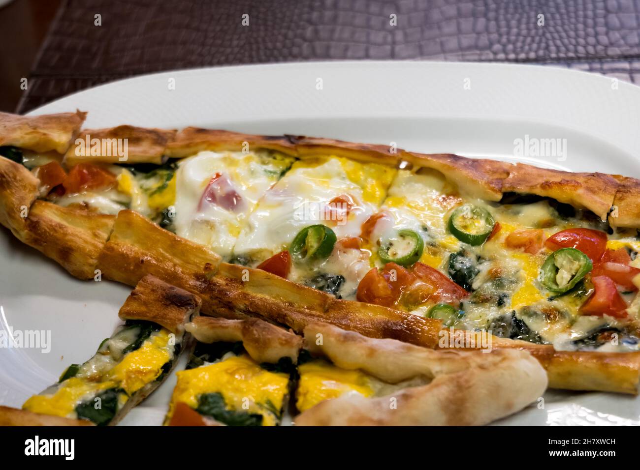 Pide, Turkish bread with meat and cheese topping, close up. Traditional ...