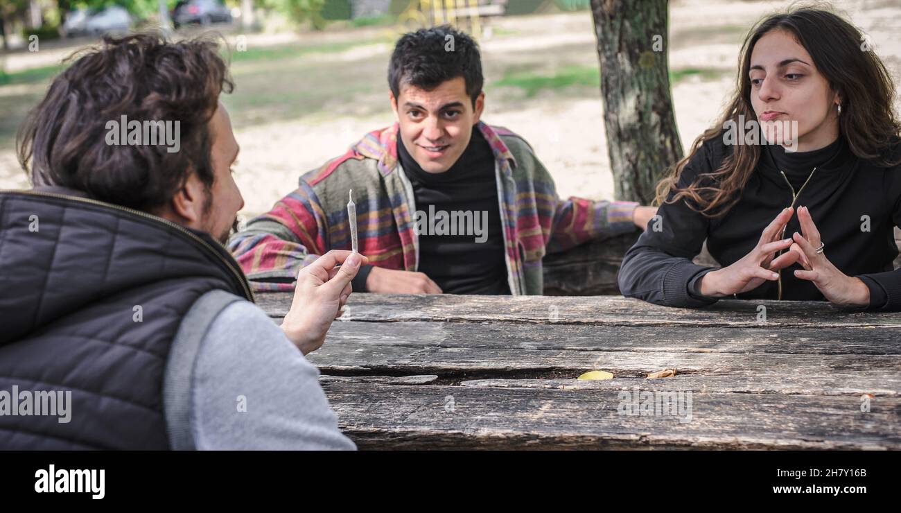 One friend shows the others excited happy friends a wrapped marijuana ...
