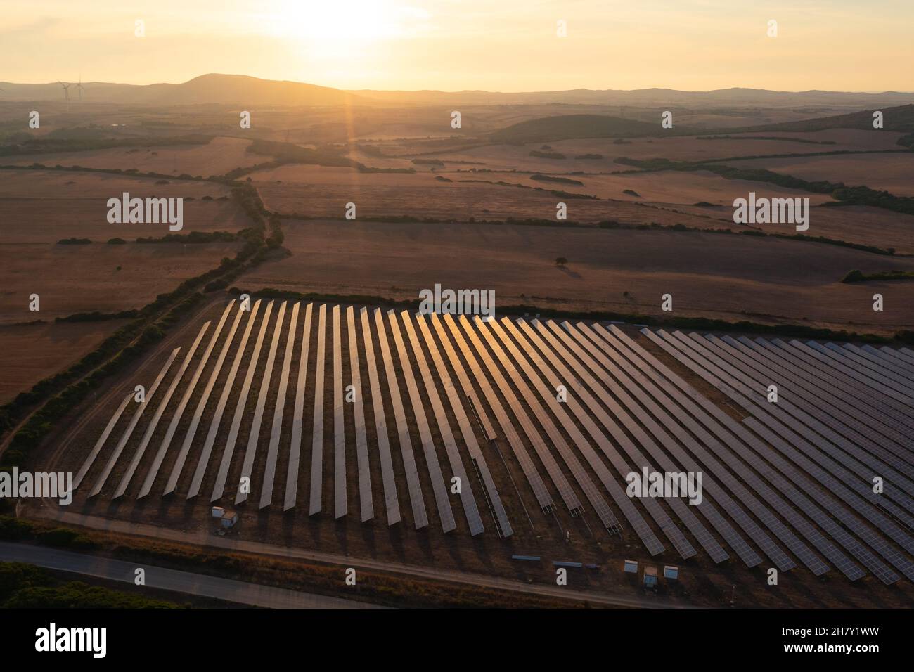 Drone view of a solar farm surrounded with brown, fertile plowed soil ...